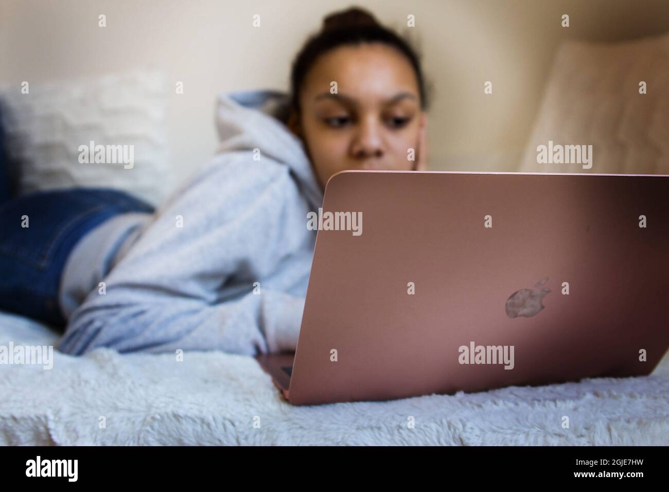 Teenage girl on her bed using a laptop computer Photo: Isabell Hojman ...