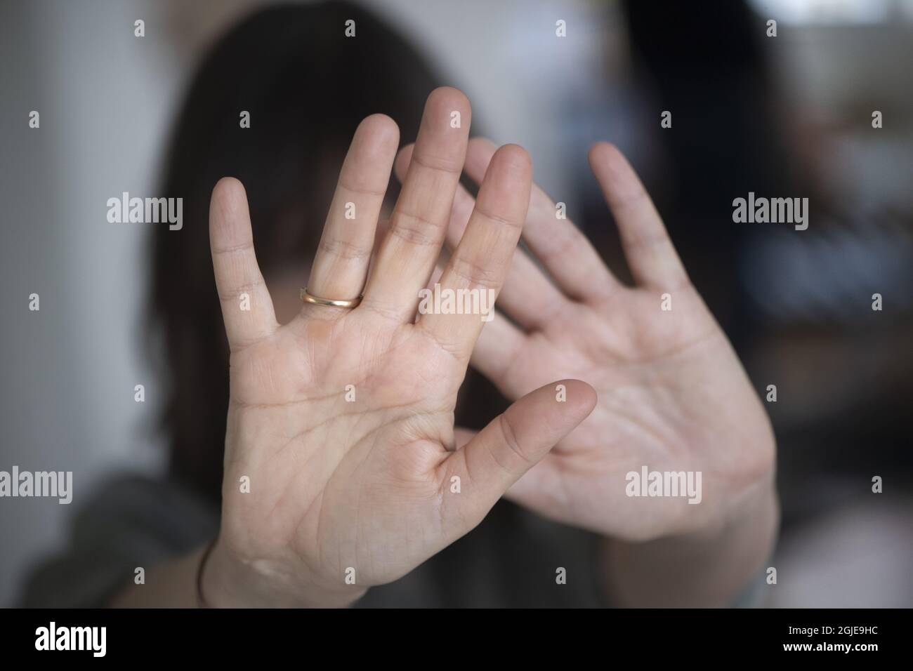 Domestic violence. A terrified, frightened, scared, woman holding up ...
