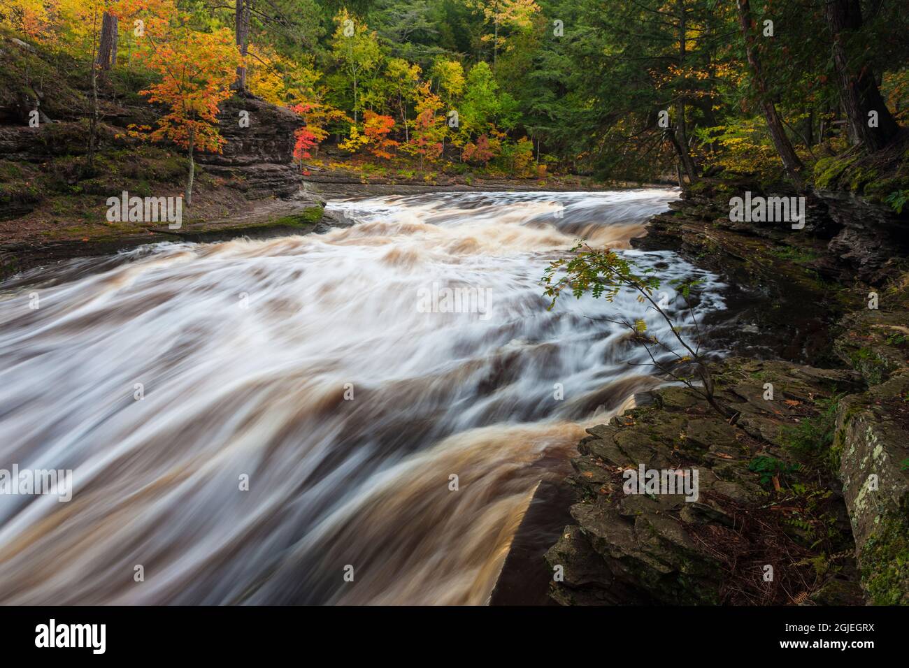 USA, Michigan. Fall colors at Presque Isle River waterfall on the south ...