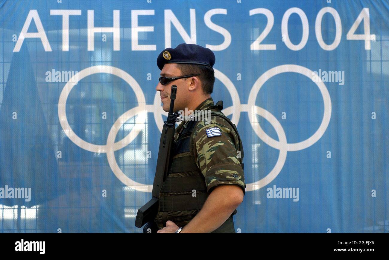 An armed security guard stands in front of the Olympic Rings at the ...
