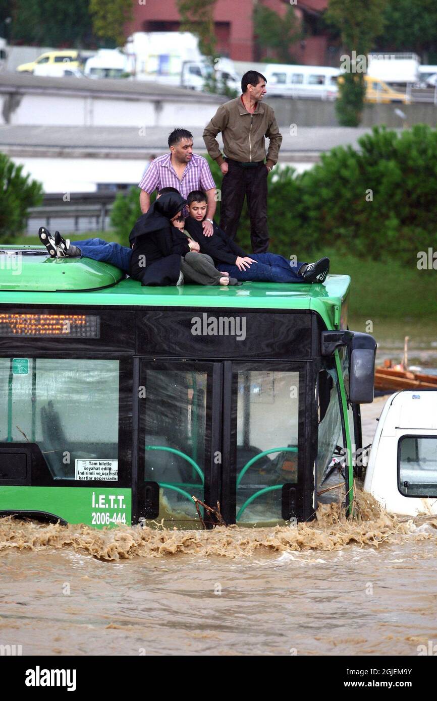 People on a partially submerged bus await evacuation on a highway in ...