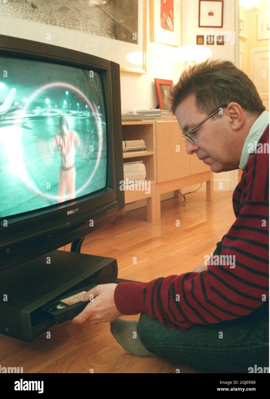 A man loading a video cassette recorder with a video tape in Stockholm ...