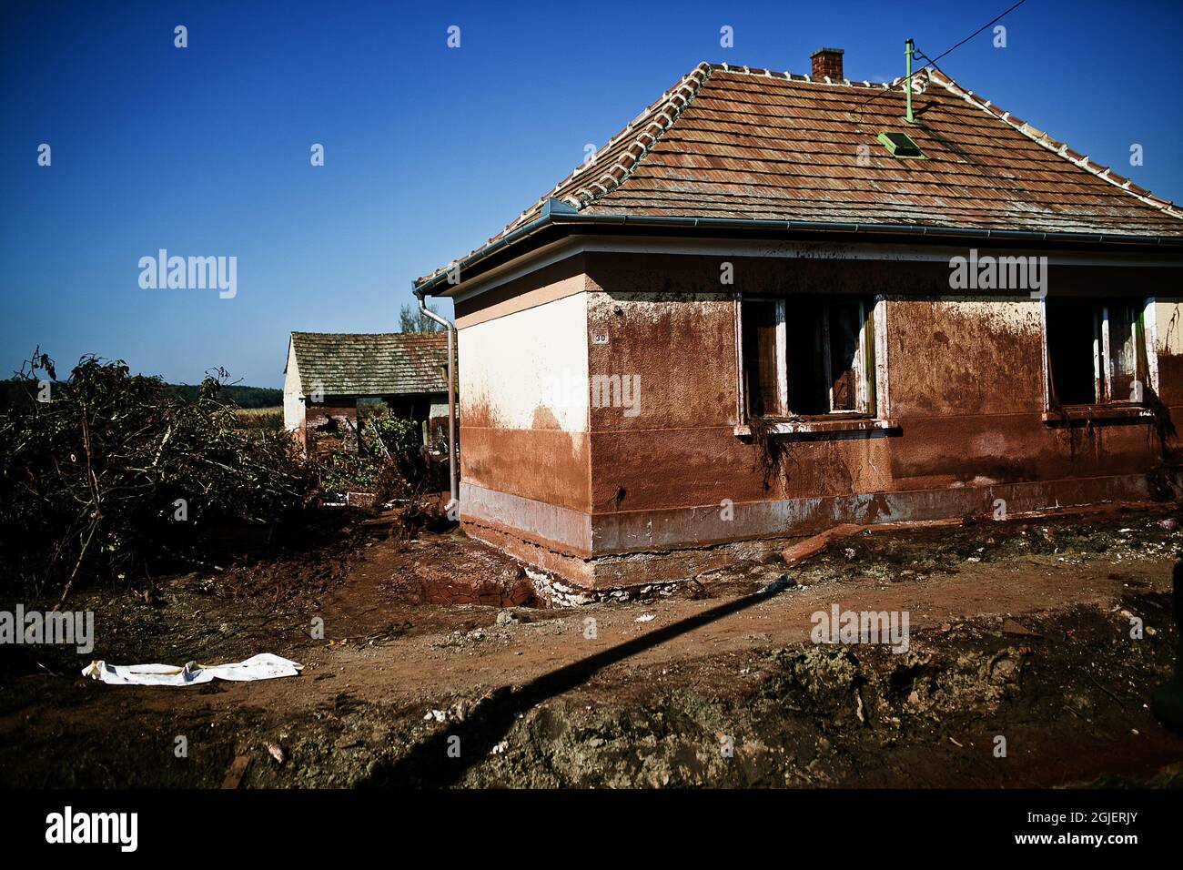 Red mud covering the wall of a house in Kolontar. A reservoir of nearby ...