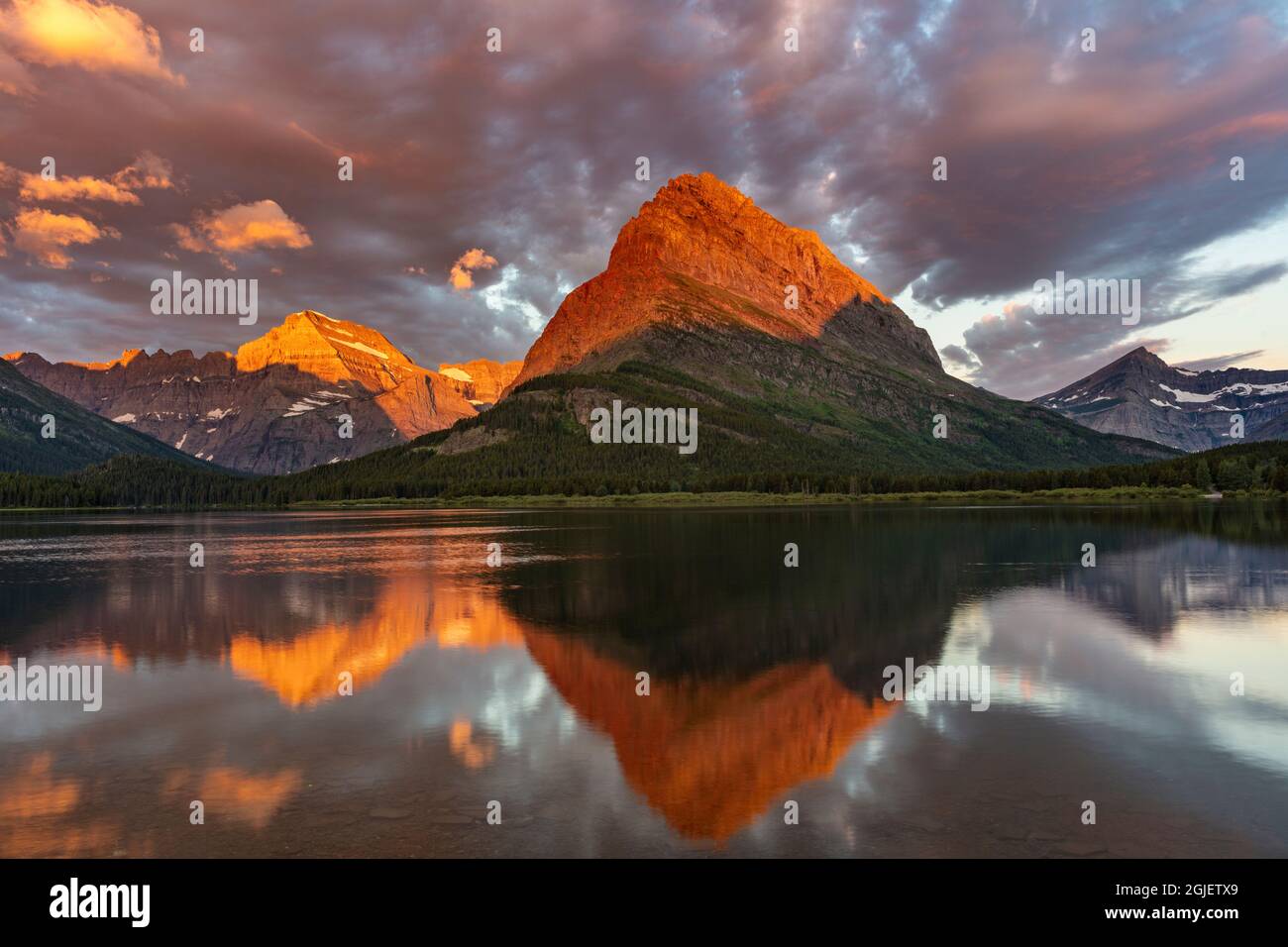 Sunrise clouds light up over Swiftcurrent Lake in Glacier National Park ...