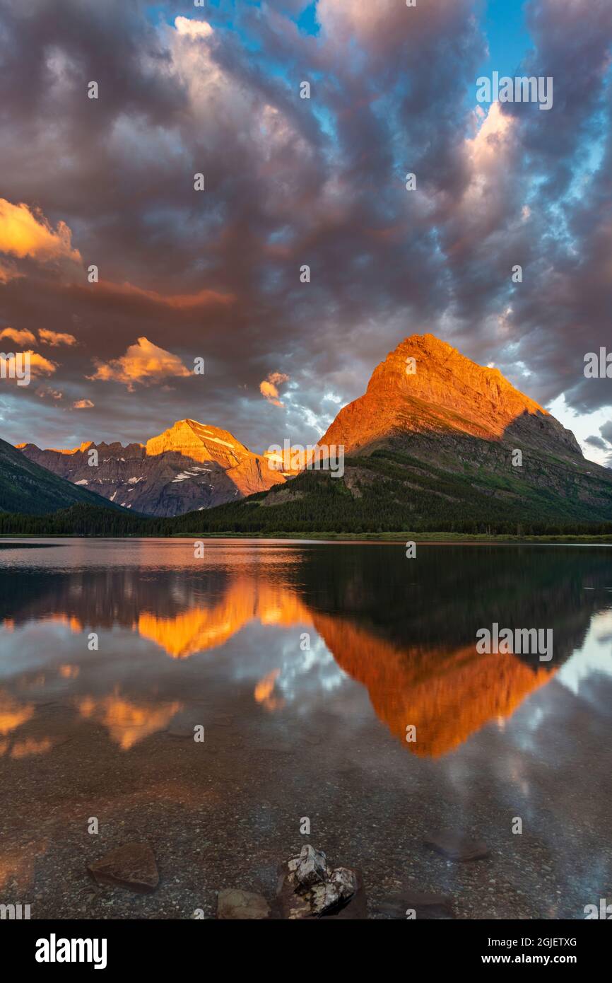 Sunrise clouds light up over Swiftcurrent Lake in Glacier National Park ...