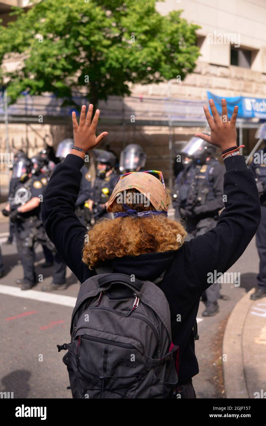 USA, Oregon, Portland. Female protester holding hands up in street ...