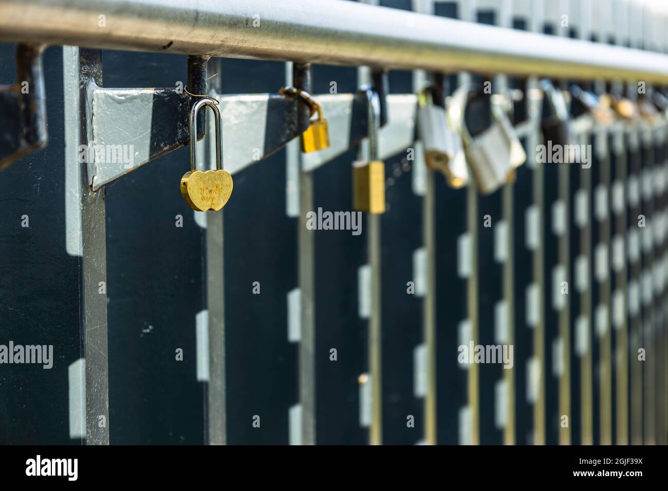 Heart-Shaped Padlock Hanging on Rails Among Other Variegated Padlocks ...