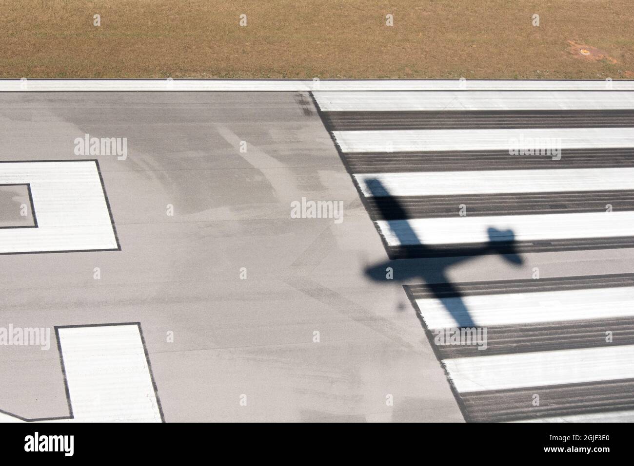 USA, Tennessee. Aerial. Shadow of airplane on runway just before ...