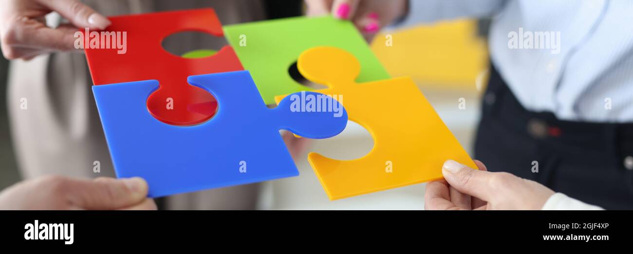Business people putting together colorful puzzle closeup Stock Photo ...
