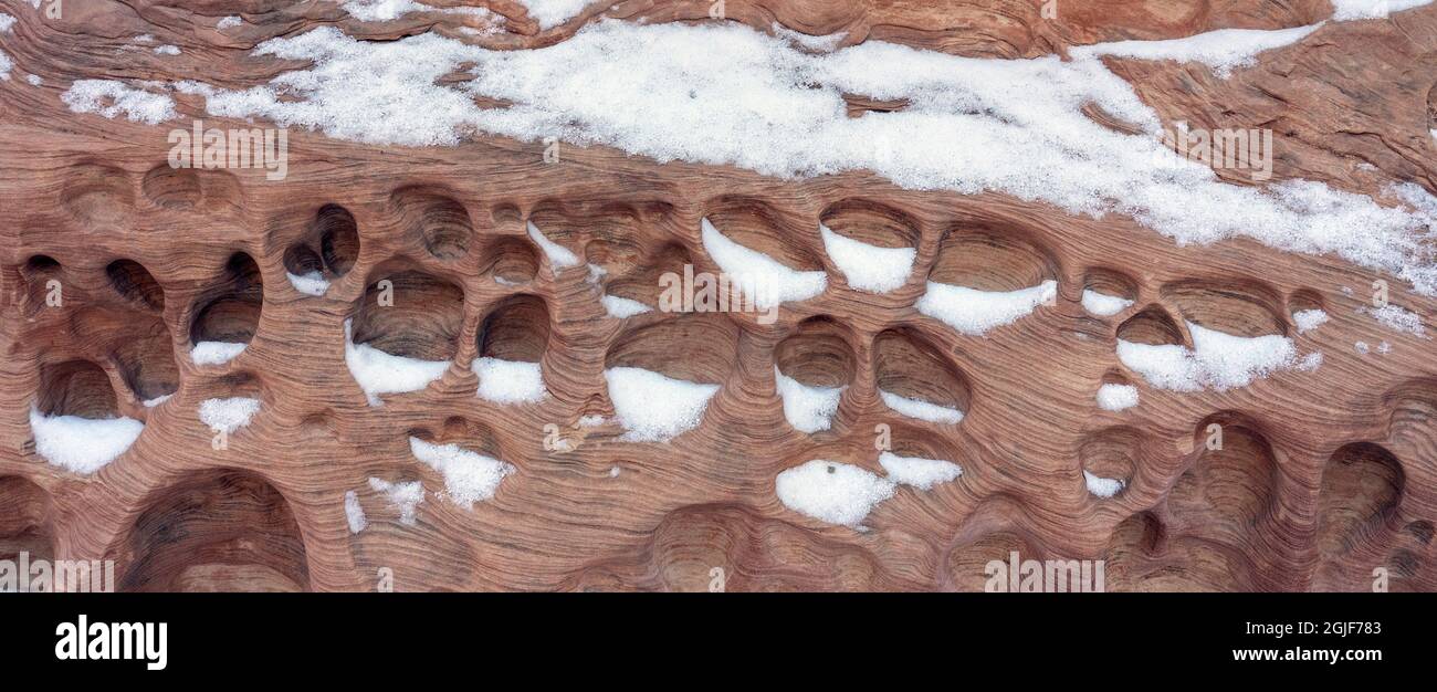 USA, Utah. Abstract erosion patterns in red rock layers with snow ...