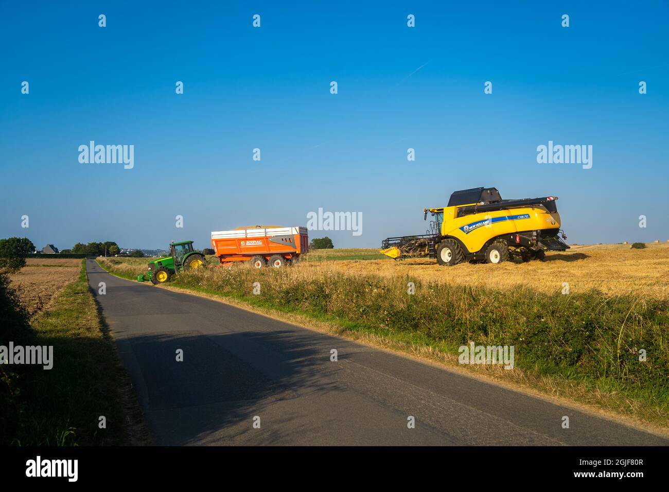 New Holland Agriculture yellow combine harvests wheat in France Bratny ...