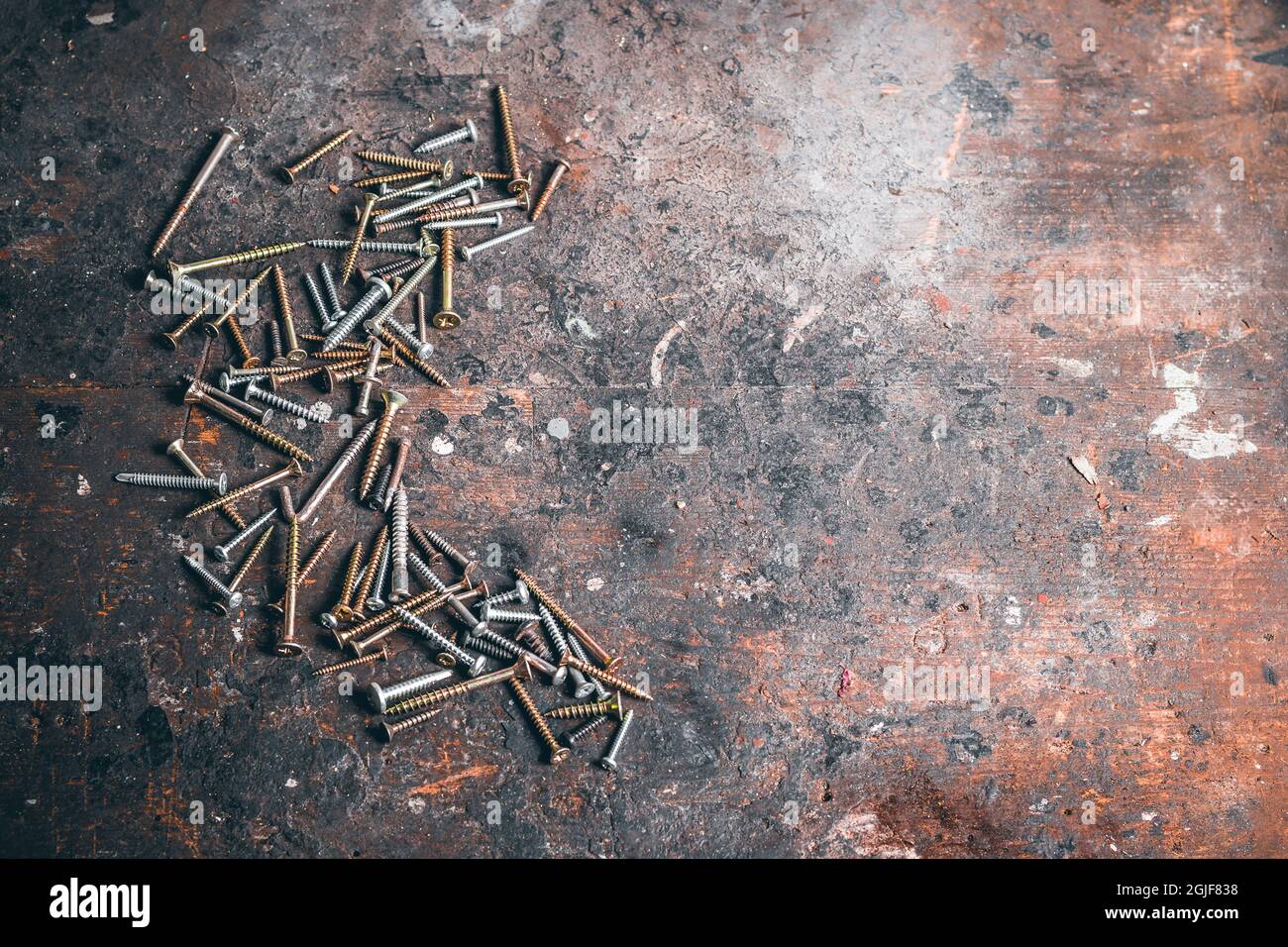 A lot of screws on wood workbench. Different Kind of Screws on a table ...
