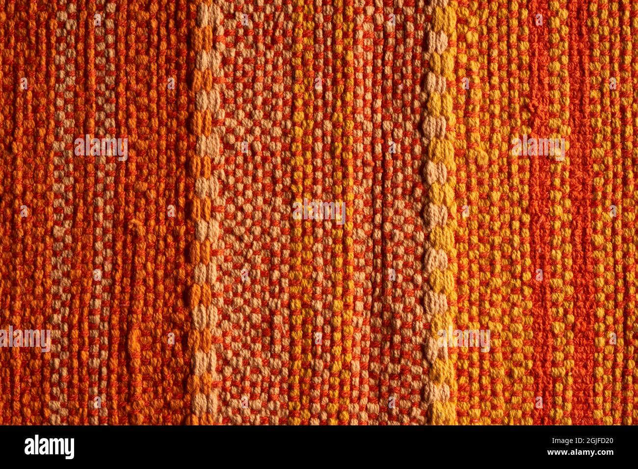 Closeup of orange, red, and yellow tapestry fabric texture background ...