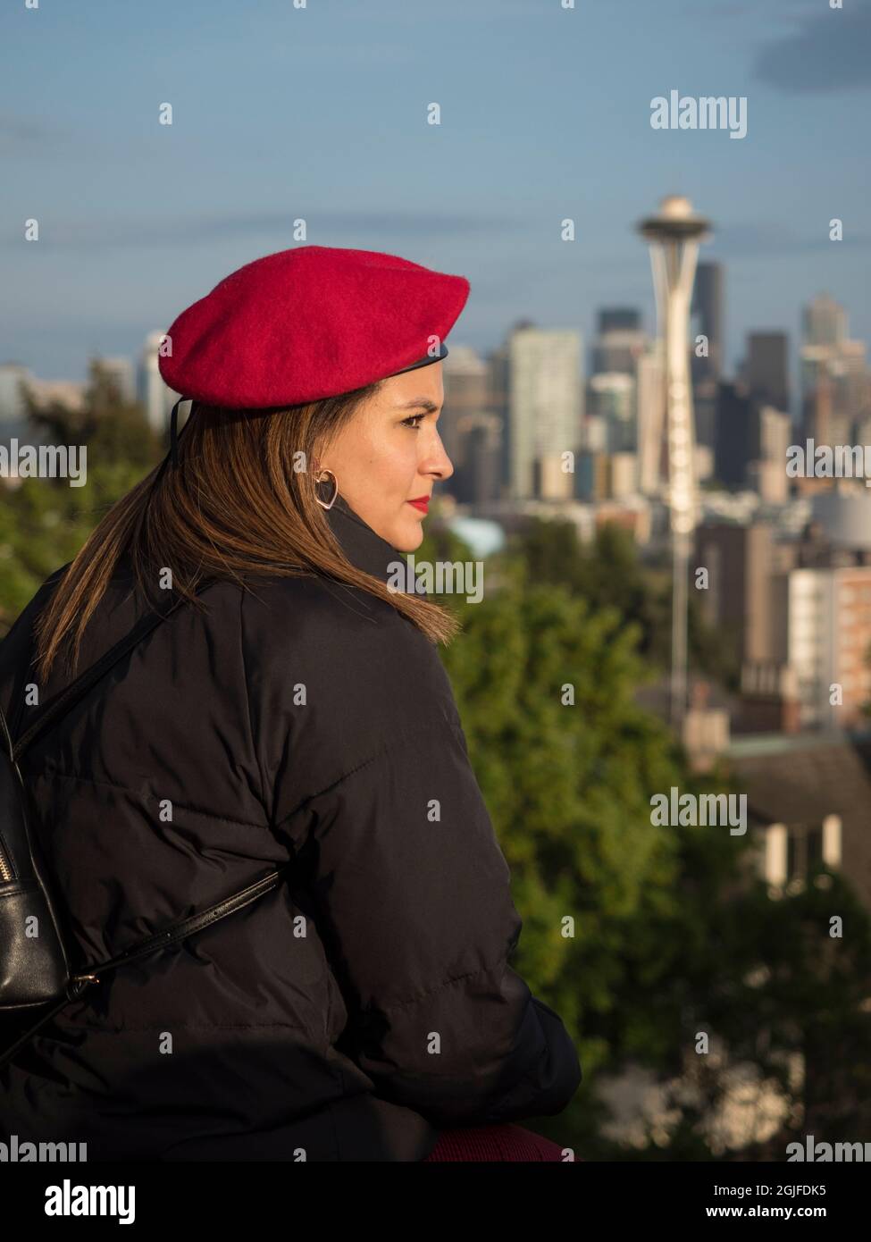 Usa, Washington State, Seattle. A young woman in a red beret looks out ...