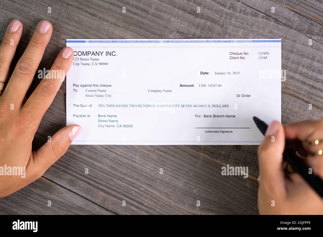 Writing Payroll Check. Hands Signing Cheque Document Stock Photo - Alamy