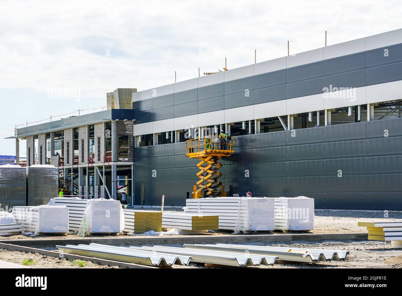 unfinished factory building wall covered with sandwich type panels ...