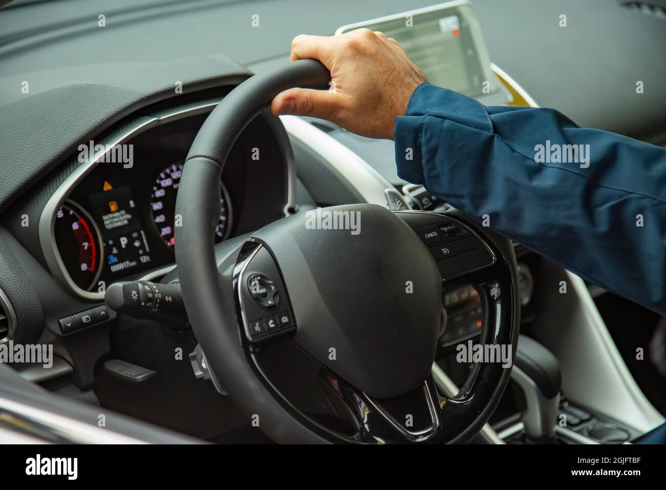 male hand on the steering wheel of a modern car. multifunction steering ...