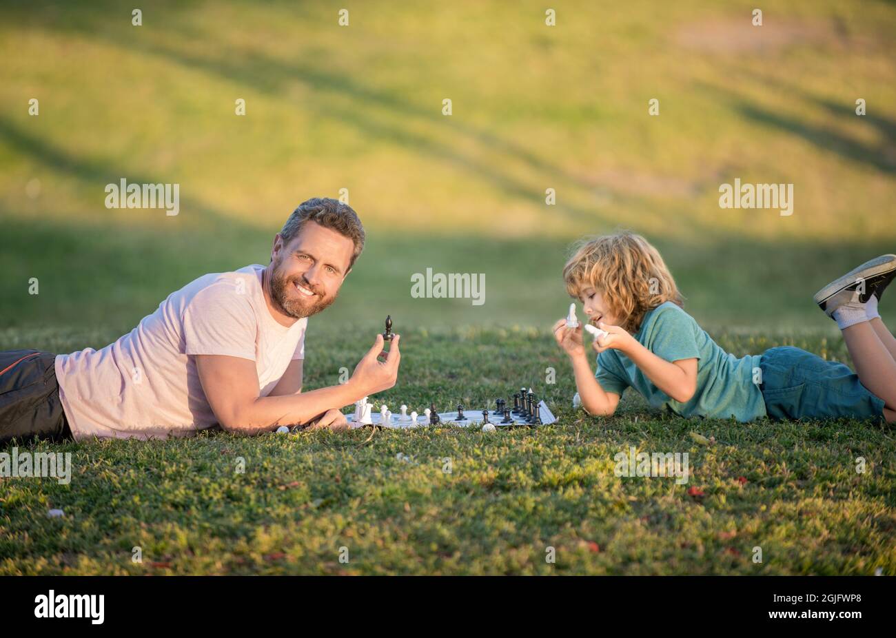 friendship. dad and kid play logic game. father and son playing chess ...