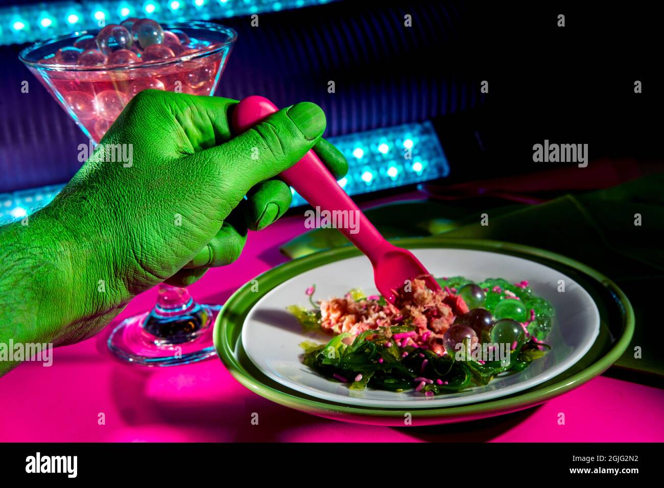 Science fiction green alien from outer space eating dinner at a fancy ...
