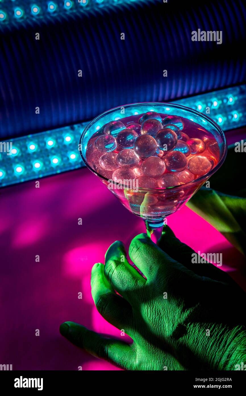 Science fiction green alien from outer space having a martini at a ...