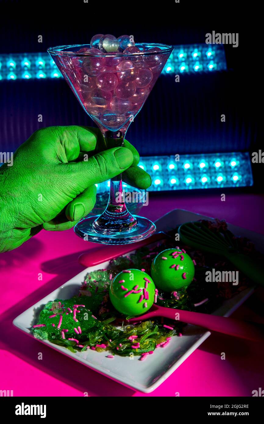 Science fiction green alien from outer space eating dinner at a fancy ...