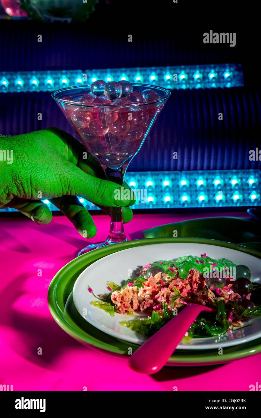 Science fiction green alien from outer space eating dinner at a fancy ...