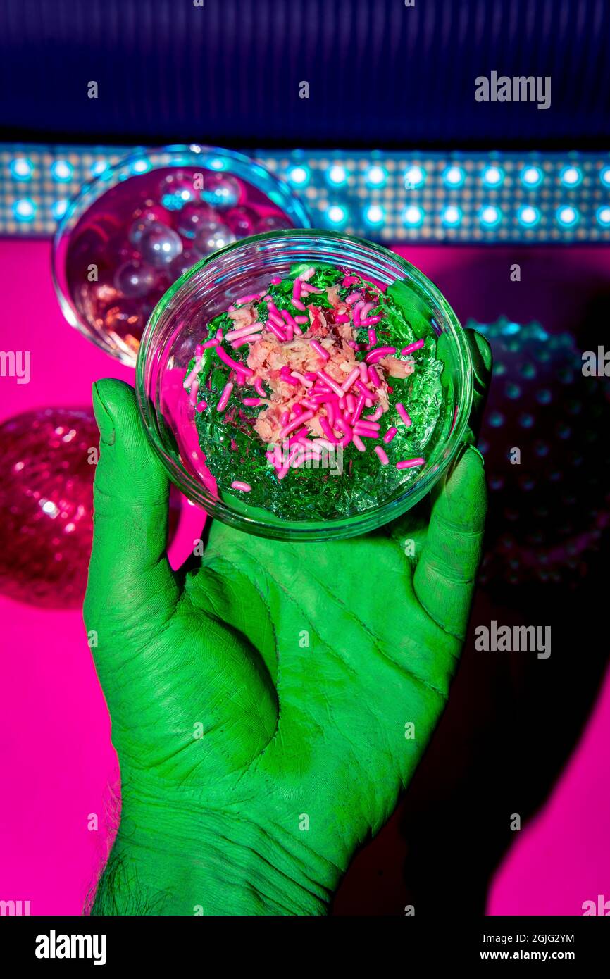 Science fiction green alien from outer space eating dinner at a fancy ...