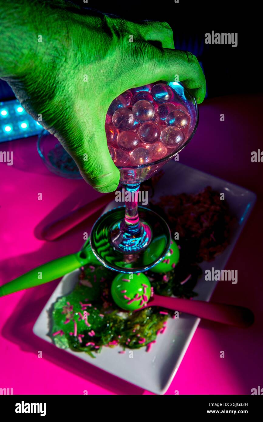 Science fiction green alien from outer space eating dinner at a fancy ...