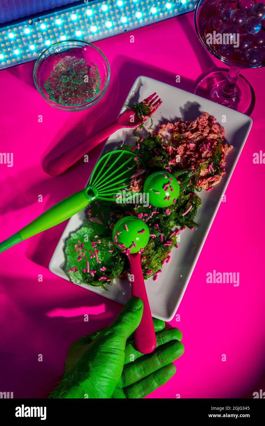 Science fiction green alien from outer space eating dinner at a fancy ...