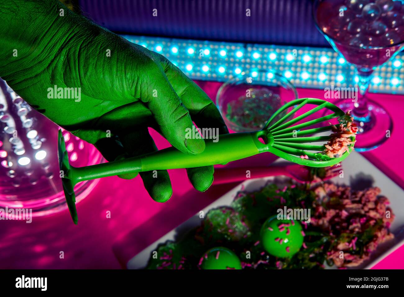 Science fiction green alien from outer space eating dinner at a fancy ...