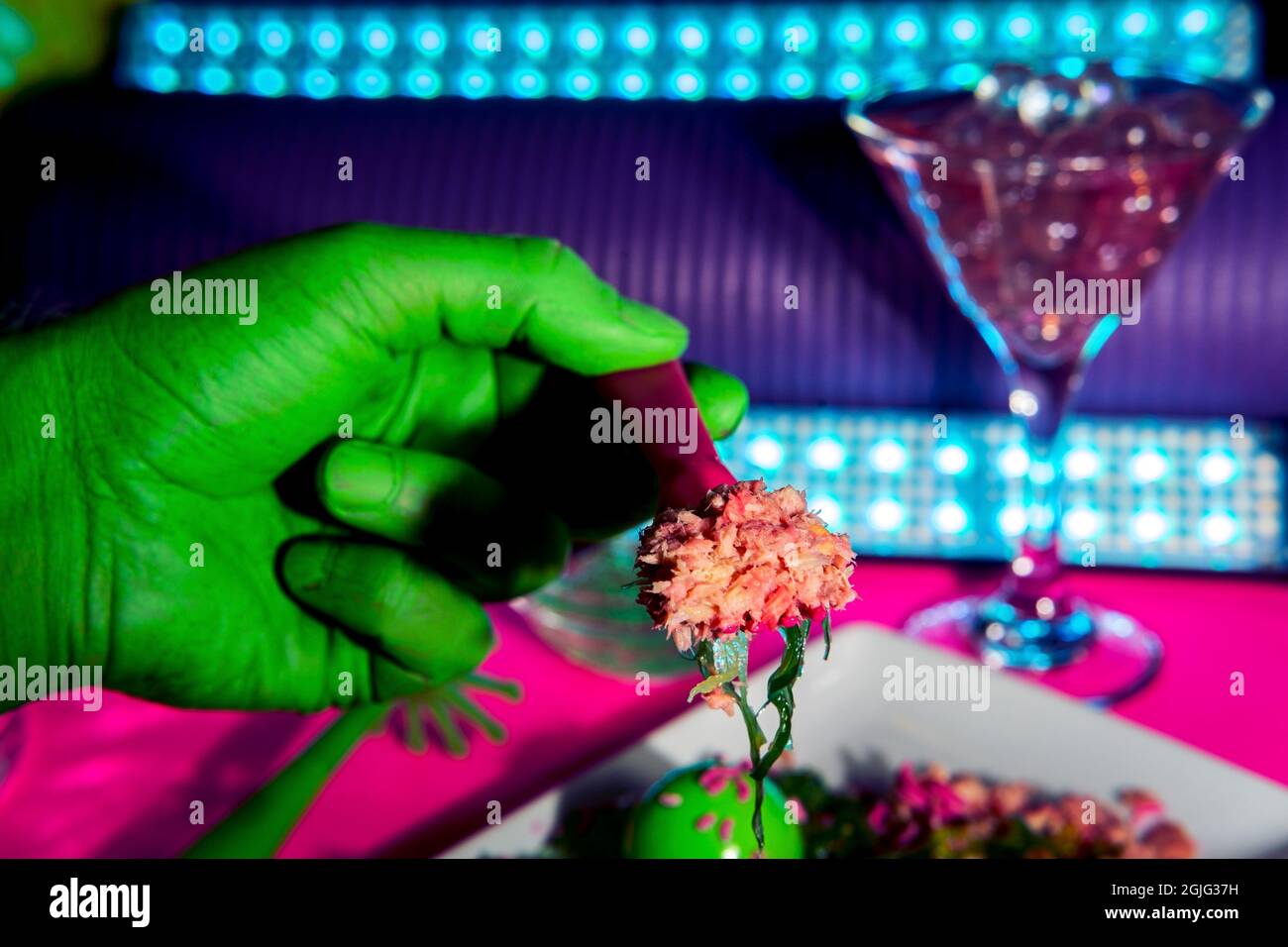 Science fiction green alien from outer space eating dinner at a fancy ...