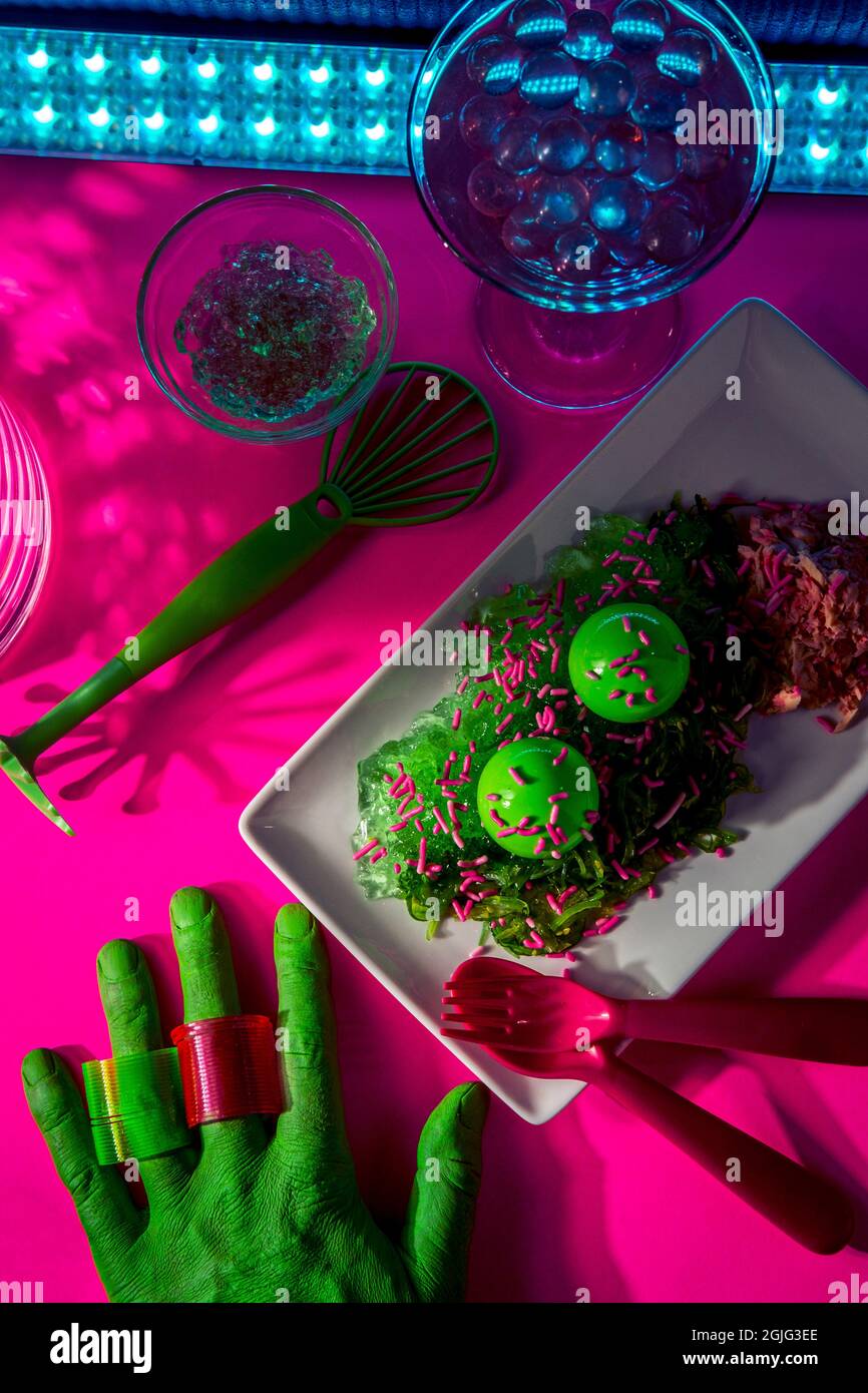 Science fiction green alien from outer space eating dinner at a fancy ...