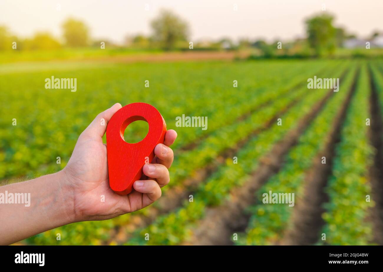 Red location pin on farm field. Buying and selling land. Land market ...