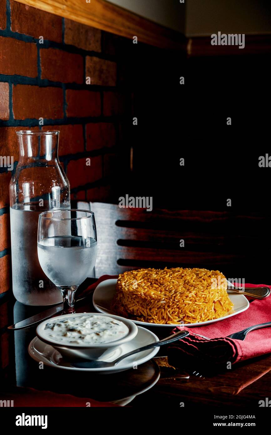 Spicy Indian chicken biryani rice with fresh raita Stock Photo - Alamy