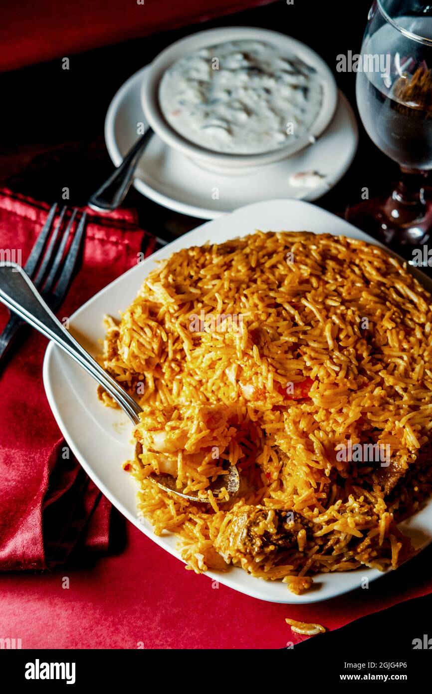 Spicy Indian chicken biryani rice with fresh raita Stock Photo - Alamy