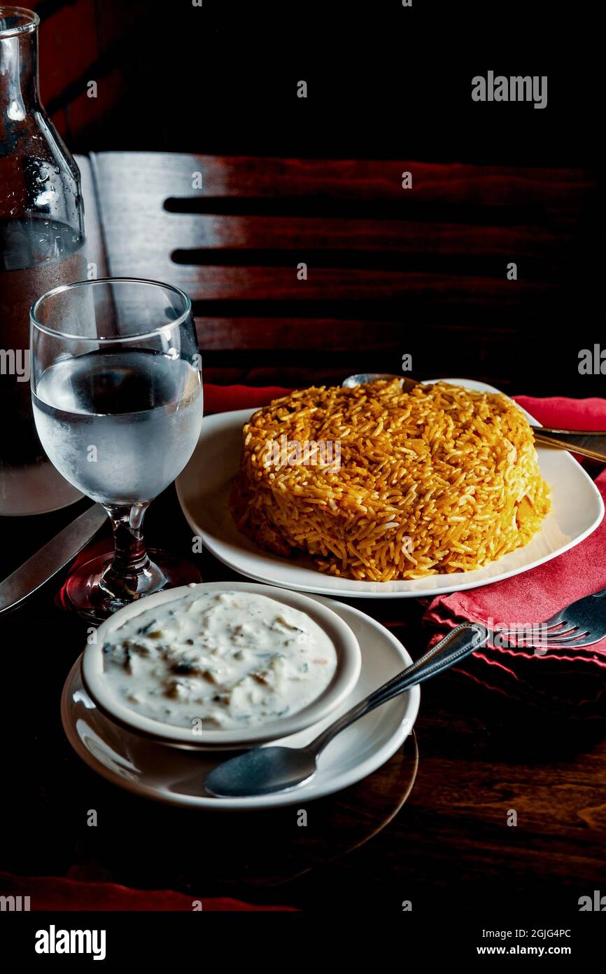 Spicy Indian chicken biryani rice with fresh raita Stock Photo - Alamy