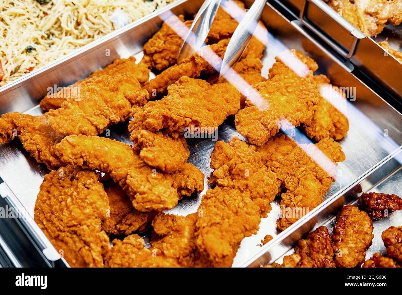 Crispy hot chicken tenders in serving tray at buffet Stock Photo - Alamy