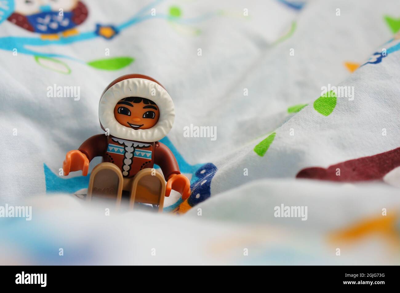 POZNAN, POLAND - Jul 09, 2017: Lego eskimo figurine sitting on a soft ...