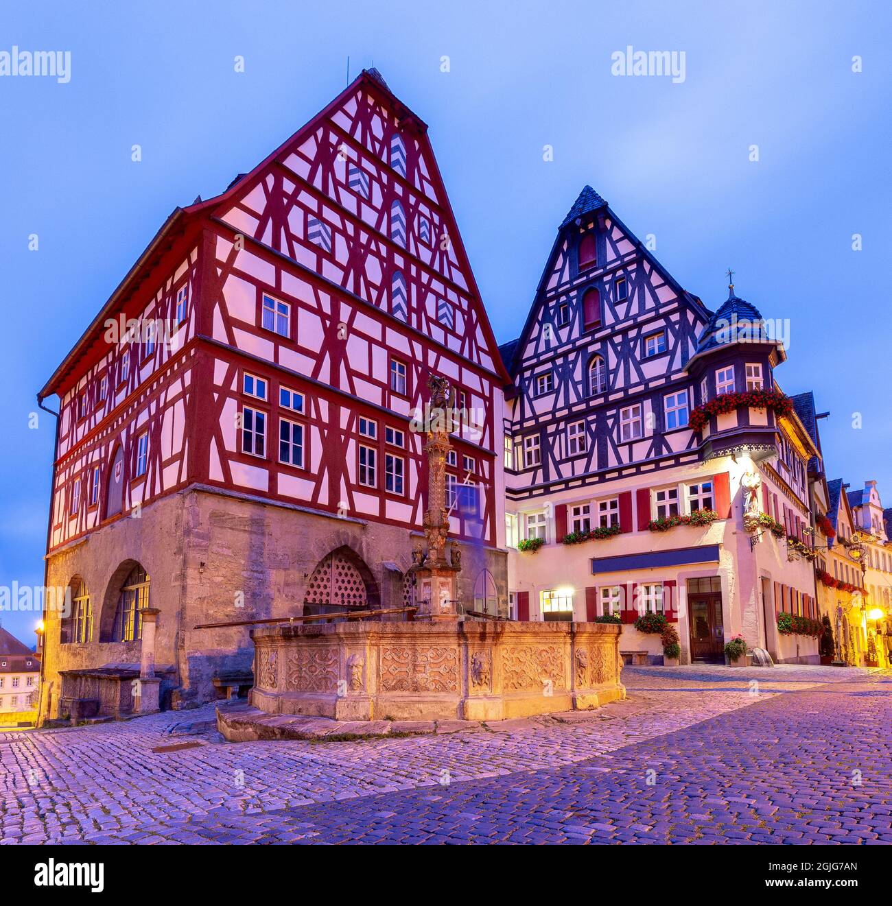 Old traditional medieval street in night illumination. Rothenburg ob ...