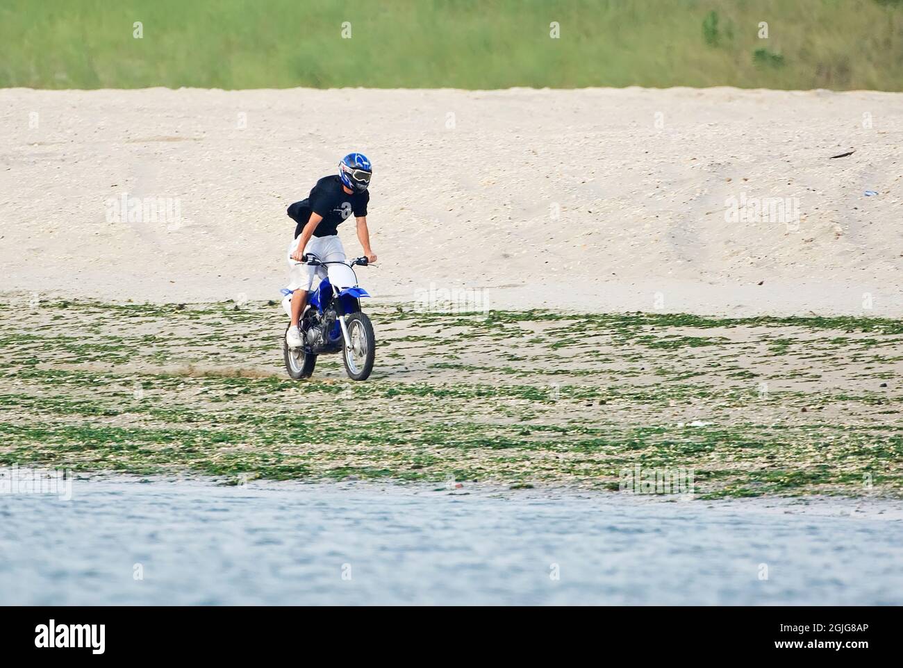 Teenager riding motorized bike at Breezy Point Gateway NRA beach during ...