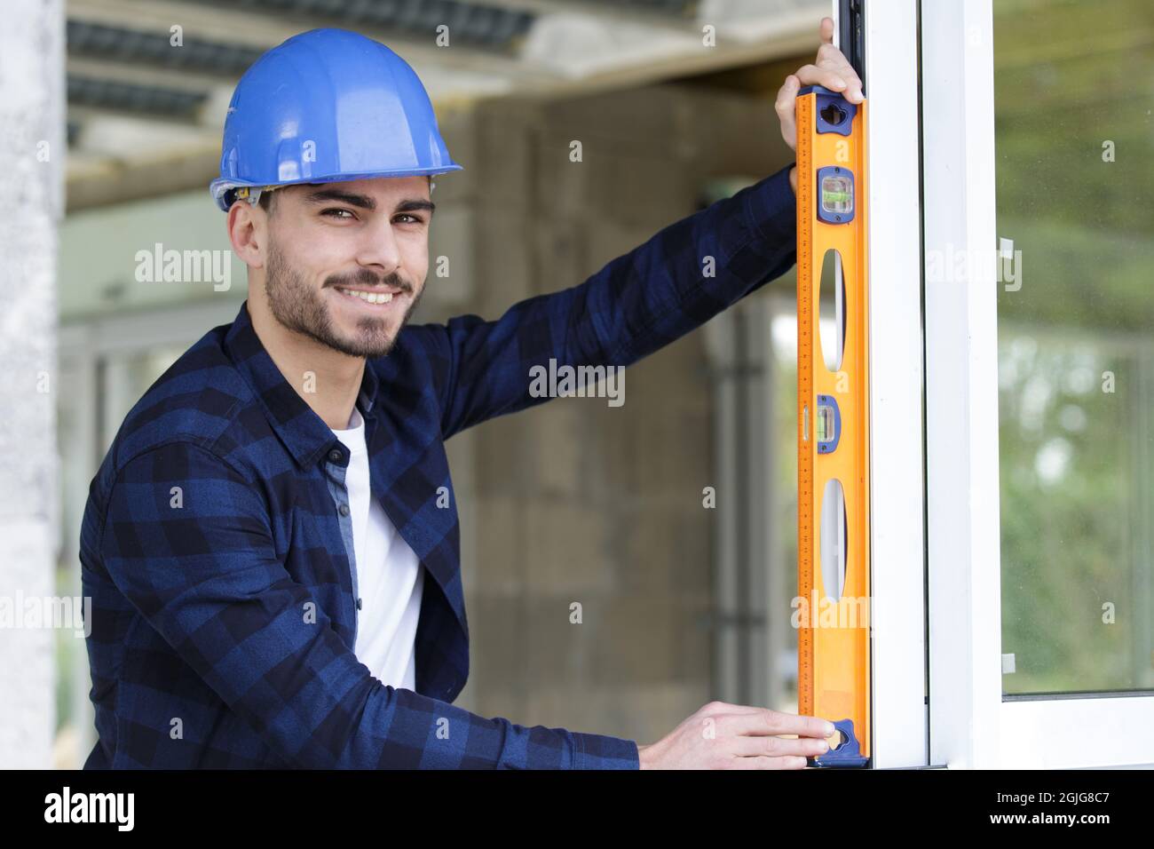 builder checking wall with spirit level Stock Photo - Alamy