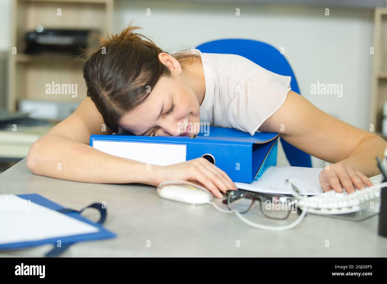 tired sleepy woman working at office desk Stock Photo - Alamy