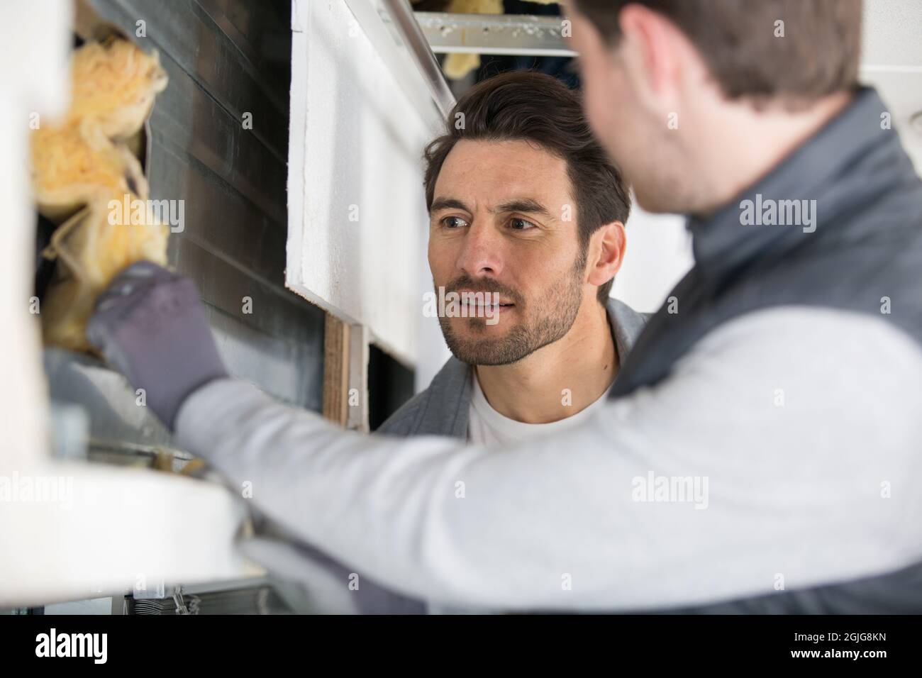 young man talking to boss during blind installation Stock Photo - Alamy