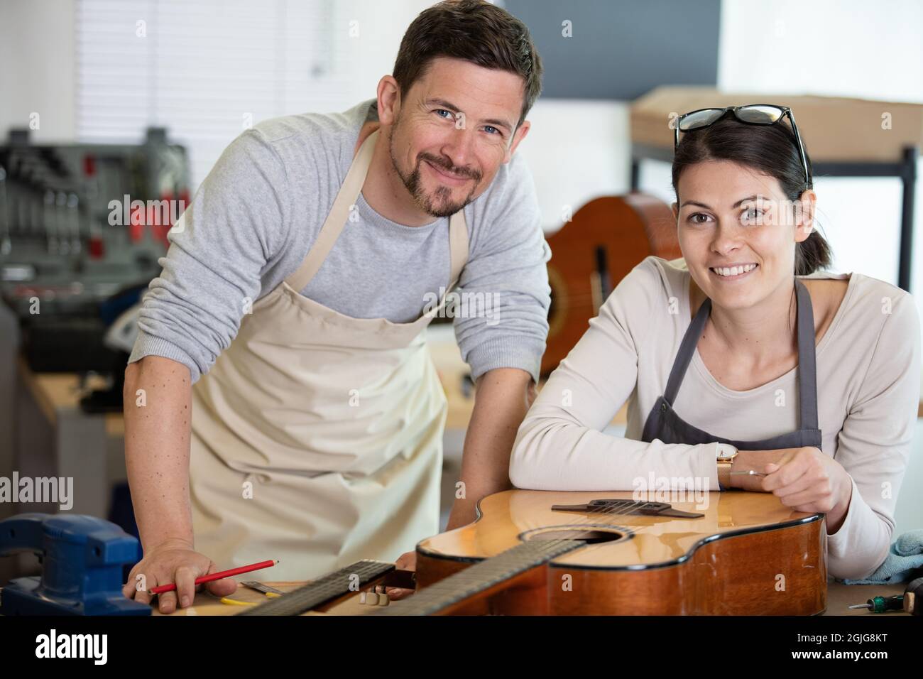 male and female luthiers repair guitar Stock Photo - Alamy