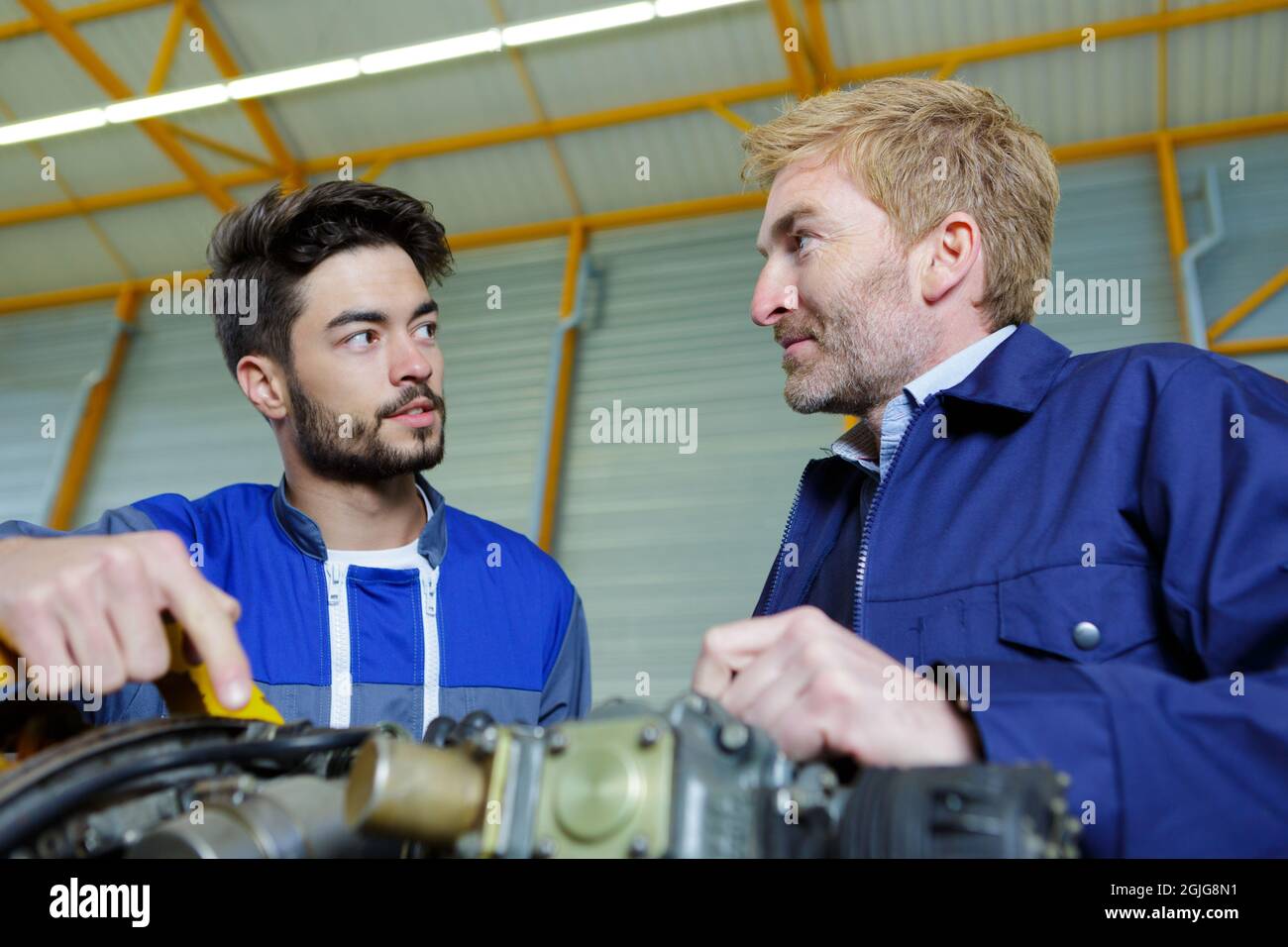 two mechanics working on a small aircraft in a hangar Stock Photo - Alamy
