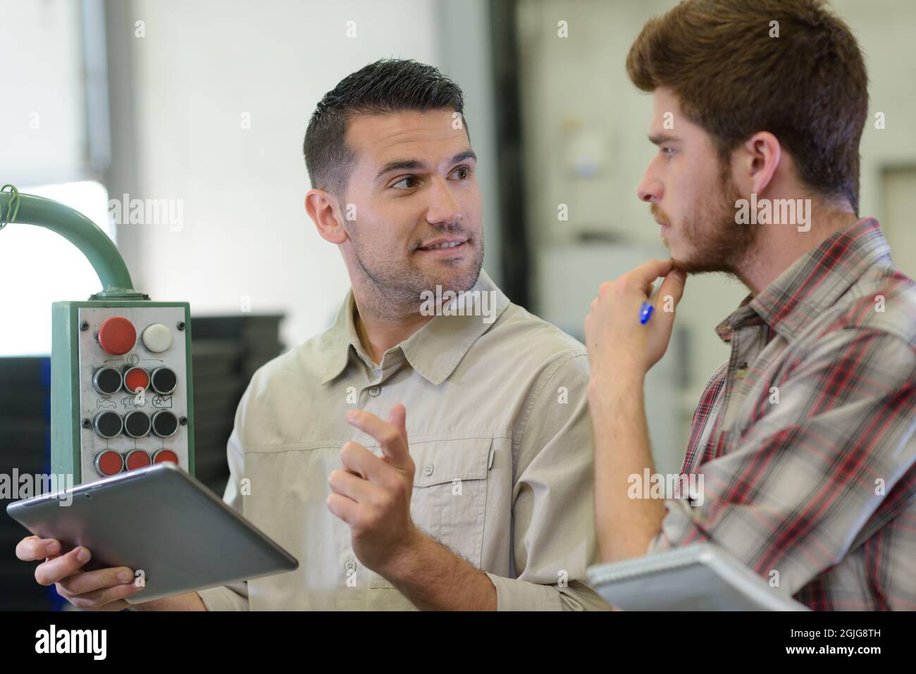 engineer training young male apprentice on cnc machine Stock Photo - Alamy