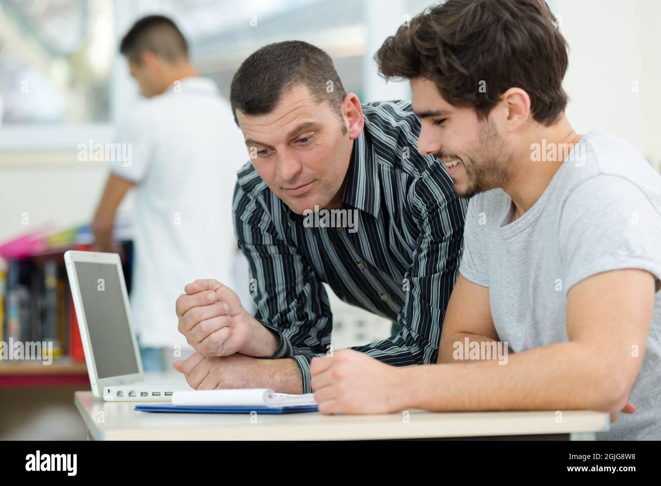 student discussing with teacher in classroom Stock Photo - Alamy