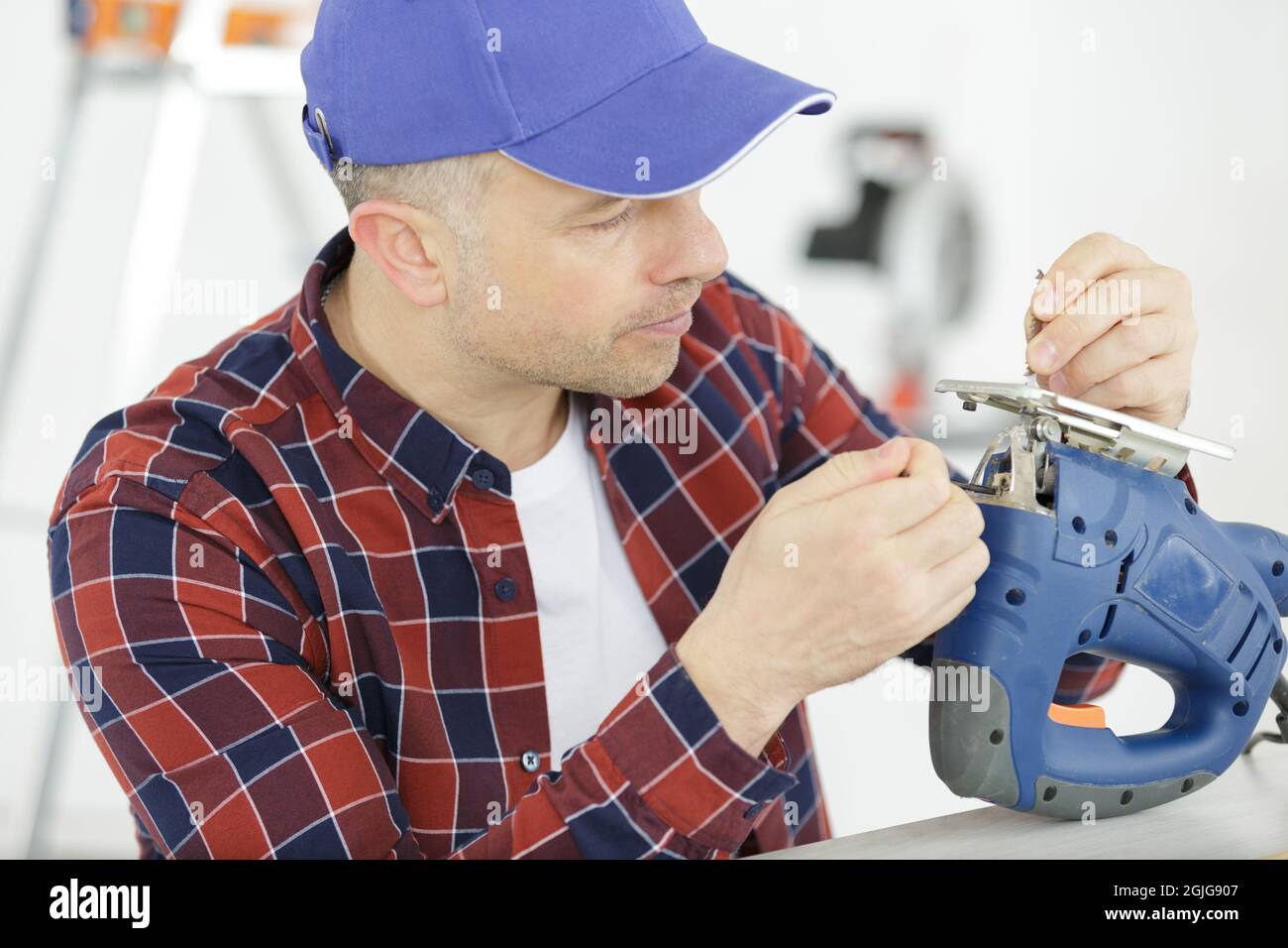 man fixing the blade in an electric jigsaw tool Stock Photo - Alamy