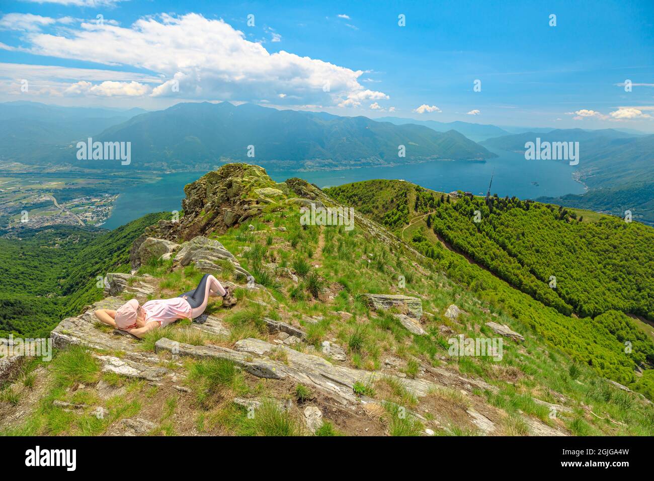 woman relaxing on top of Cardada-Cimetta mount in Switzerland. Skyline ...
