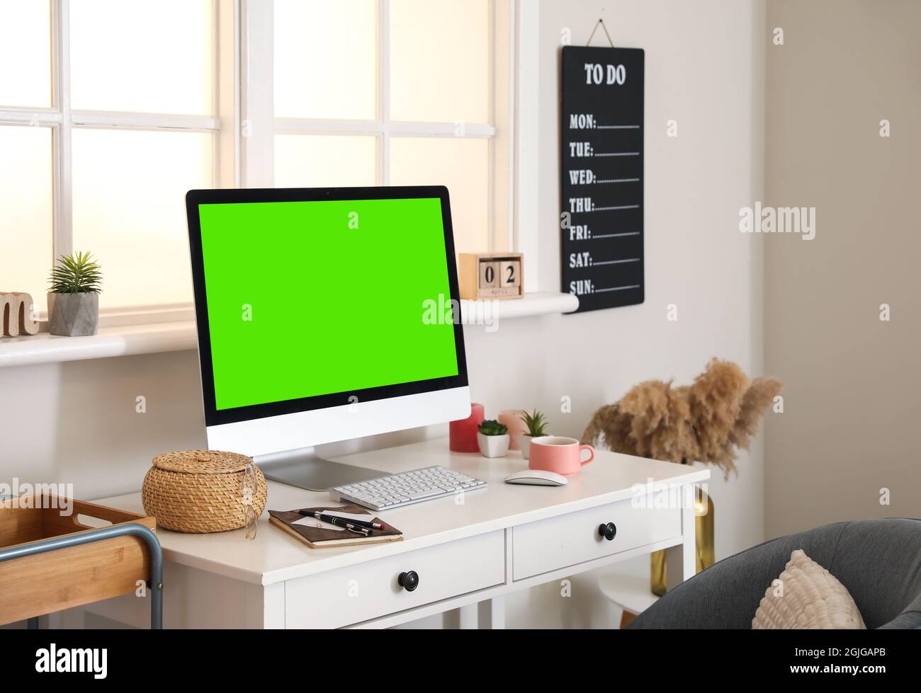 Modern computer with blank screen at workplace in interior of room ...
